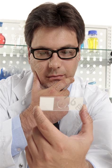 拿着磨砂玻璃显微镜载玻片的科学家 包图企业站