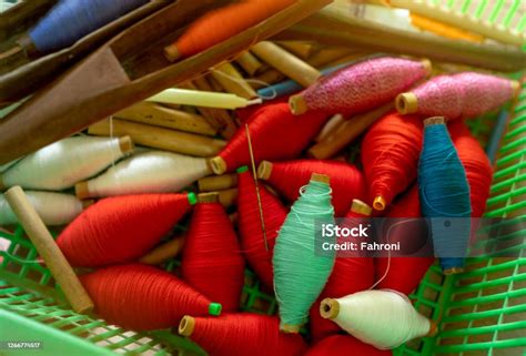 스풀의 컬러풀한 원사와 플라스틱 바구니에 있는 빈 나무 스풀을 볼 수 있습니다 셔틀 도구를 짜는 원사 섬유 직물 직조 도구 전통적인 직조 직조 직조를위한 장비 천 생산 0