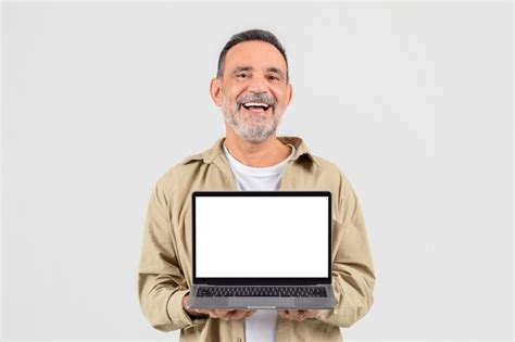 Premium Photo Mature Man Presenting A Blank Laptop Screen