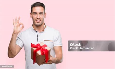 선물을 주는 잘생긴 젊은 남자 손가락 우수한 기호 확인 표시를 하 고 개념에 대한 스톡 사진 및 기타 이미지 개념 개념과