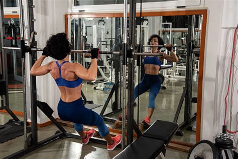 체육관에서 심각 하 게 운동 하는 등 여자는 멀티 파워를 사용 합니다 젊은 근육 질의 여자의 전체 그림입니다 거울에 대한 스톡 사진 및 기타 이미지 Istock