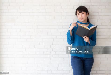 집에서 콘크리트 시멘트 흰색 배경에 노트북을 생각 하 고 쓰기 서 서 웃는 아름 다운 아시아 여자 책 교육 및 라이프 스타일 개념에 소녀 숙제 가정 생활에 대한 스톡 사진