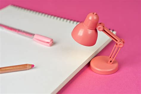 분홍색 배경에 메모장 노트북 근처의 장난감 테이블 램프 램프 근처의 텍스트를 위한 공간과 여유 공간을 복사합니다 루치 공간과 창조적 인 아이디어의 개념 0명에 대한 스톡