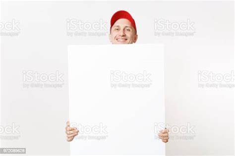 배달 젊은이 빨간색 유니폼에 흰색 배경에 고립 남성 택배 들고 큰 하얀 빈 종이 빌보드 T셔츠 모자 공간 광고를 복사 합니다 텍스트 또는 이미지를 위한 장소 광고 영역