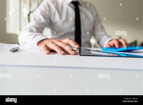 Designer Or Architect Working On A Project Drawing A Draft Using Calculator And Ruler Stock