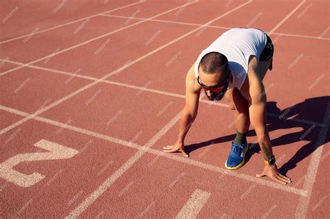 Premium Photo A Man Is Ready To Start A Race On A Track