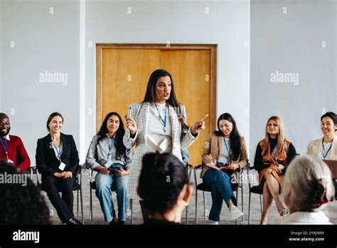 A Female Instructor Is Engaged In Addressing A Diverse Group Of People