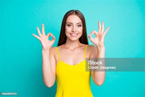 명랑 한 다행 재미 긍정적인 좋은 매력적인 귀여운 스트레이트 머리 여자의 밝은 Tanktop에 보여주는 이중 확인서명 세로 녹색 청록색 배경 위에 절연 십대 소녀에 대한