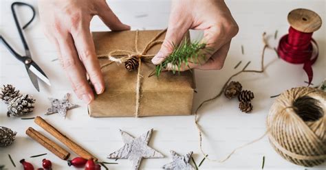 흰색 배경에 크리스마스 구성입니다 포장된 선물을 장식하는 여성의 손 사진 Unsplash의 가위 이미지