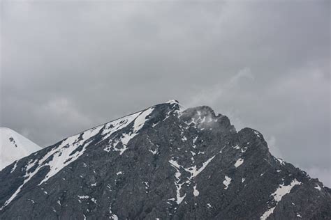흐린 회색 흐린 하늘에 눈 처마가있는 높은 산봉우리와 흑백 풍경 회색 규모의 비오는 날씨에 리드 회색 하늘에 큰 절정과 어두운 분위기의 산 풍경 0명에 대한 스톡 사진 및