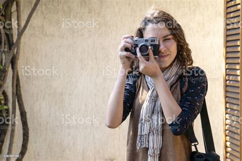 맑은 벽 배경으로 화창한 여름 날에 정원에서 디지털 빈티지 카메라로 사진을 찍는 젊은 예쁜 소녀 여행 예술 자유 사진 청소년 및 기술 개념 관광객에 대한 스톡 사진 및 기타