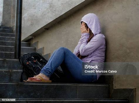 슬 프 고 우울 젊은 학생 여자 또는 왕 따 십 대 소녀 느낌 절망 고통 우울증 문제를 왕 따의 거리 계단 무서 워 하 고 불안 피해자에 야외에서 앉아 가리기에 대한 스톡