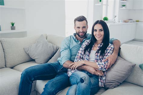 현대 아파트에서 함께 시간을 즐기고 카메라 보고 수용 거실에 소파에 앉아 트렌디한 세련 된 부부의 초상화 사랑에 대한 스톡 사진 및 기타 이미지 Istock