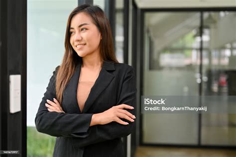 공식적인 양복을 입은 성공적인 아시아 사업가가 팔을 뚫고 사무실에 서 있습니다 25 29세에 대한 스톡 사진 및 기타 이미지