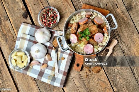 오래된 냄비 소시지 신선한 마늘 전구 정향 색깔의 후추 나무 숟가락 크루통 및 소박한 나무 테이블에 수건에 마늘 수프의 상단 보기 건강한 식생활에 대한 스톡 사진 및 기타