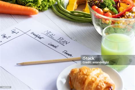 칼로리 제어 식사 계획 음식 다이어트와 체중 감소 개념 샐러드 과일 주스 빵 야채와 종이에 식사 계획 테이블의 상단보기 0명에