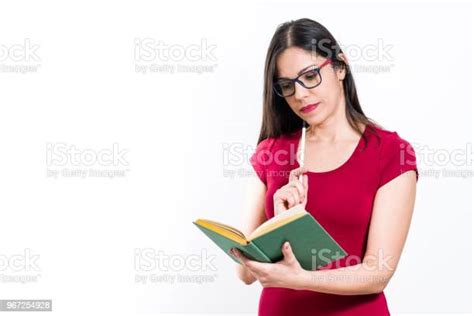 흰색 바탕에 고립 된 젊은 아름 다운 갈색 머리 여 자가 빨간색 셔츠와 안경 심각한 흰색 연필 및 녹색 커버도 서와도 서를 찾고 공부 갈색 머리에 대한 스톡 사진 및 기타