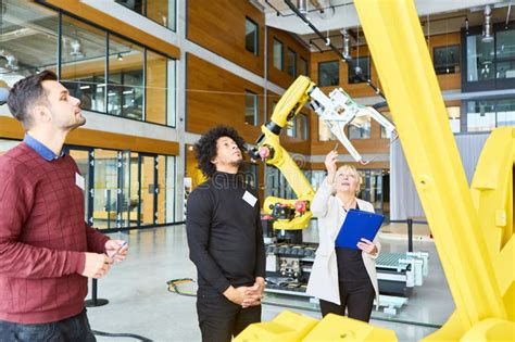 Team Of Engineers Programming A Robotic Arm In A Modern Industrial Facility Stock Image Image