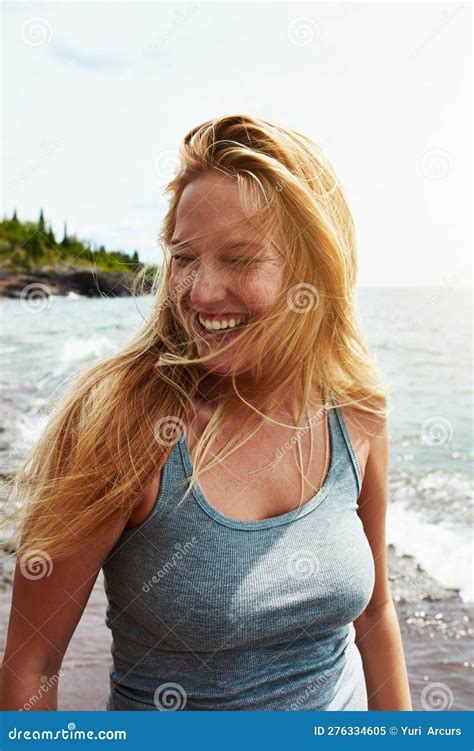 Nothing Can Spoil Her Mood A Cheerful Young Woman Standing On A Beach While Looking In A