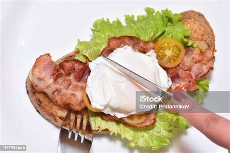 여성의 손은 나이프와 튀긴 베이컨 및 체리 토마토와 아름 다운 샌드위치와 튀긴 계란을 잘라 아침 식사에 대 한 건강에 해로운 음식 클로즈업 건강에 좋지 않은 음식에 대한