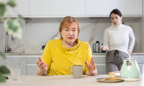 Frustrated Elderly Mother Having Tense Conversation With Her Daughter