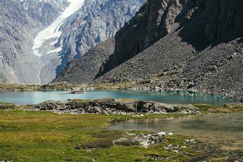 푸른 산 호수와 햇빛에 빙하와 경치 녹색 풍경 빙하 호수의 청록색 맑은 물 근처 녹색 이끼 바위 바위의 배경에 빙하 호수와 아름다운 맑은 풍경 거골에 대한 스톡 사진 및