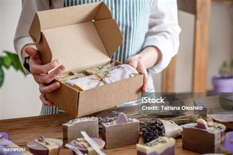 앞치마를 입은 여자는 수건과 라벤더 천연 비누 조각이 든 공예 상자를 들고 있다 수제 선물 포장 개념 30 34세에 대한 스톡 사진 및 기타 이미지 Istock