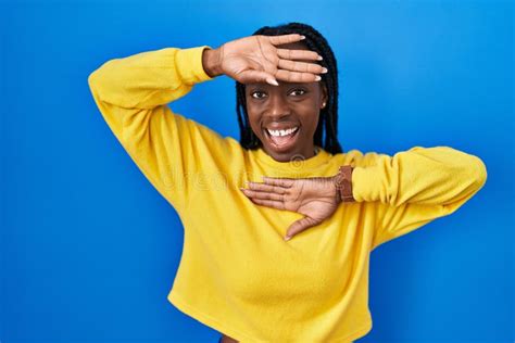 Beautiful Black Woman Standing Over Blue Background Smiling Cheerful Playing Peek A Boo With