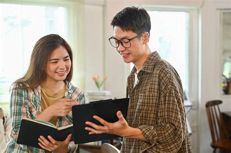 클립보드를 들고 웃는 아시아 남자 아이디어를 공유하거나 사무실에서 동료와 계획을 논의하는 모습 20 24세에 대한 스톡 사진 및 기타 이미지 Istock