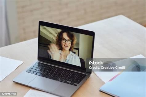 집에서 공부하는 학생들과 온라인 수업을하는 동안 화상 통화 중에 카메라를 흔들며 여성 교사 랩톱 화면에 집중 책상에 대한 스톡