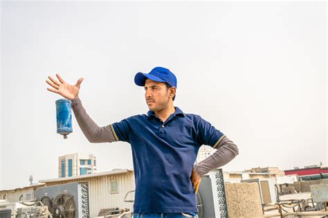 전문 전기 기술자는 지붕 상단에 무거운 공기 조화 기의 일부를 던지고 유니폼과 헤드 캡의 푸른 색을 입고 있다 Stem 주제에 대한 스톡 사진 및 기타 이미지 Istock