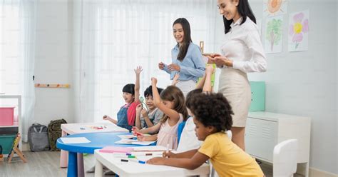 아시아의 아름다운 젊은 여성 교사가 학교에서 아이에게 수업을 가르치고 있다 매력적인 여성 강사 마스터가 유치원 교실에서 재미있는 활동으로 어린이 학생을 설명하고 교육합니다