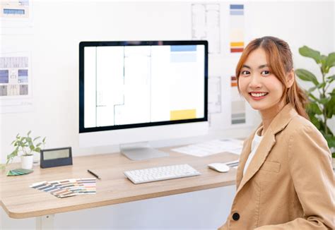 행복한 아시아 여성 인테리어 디자이너가 사무실에 앉아 창의적인 프로젝트를 진행하고 웃고 있다 쾌활한 젊은 여성 건축가의 초상화는 행복한 감정을 성공적으로 표현합니다 25