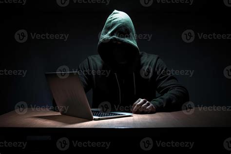 Hacker Wearing Black Hoodie Using Laptop Computer While Working On Dark