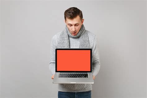 젊은 남자가 스웨터 스카프 빈 빈 화면 회색 배경에 고립 된 노트북 Pc 컴퓨터에서 찾고 있다 건강 한 생활양식 온라인 치료 컨설팅 추운 계절 개념 복사 공간을 비웃는 다