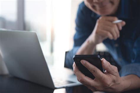 휴대 전화를 사용하고 사무실 테이블에 디지털 태블릿이있는 랩톱 컴퓨터에서 작업하는 아시아 캐주얼 비즈니스 맨의 클로즈업 55 59세에 대한 스톡 사진 및 기타 이미지