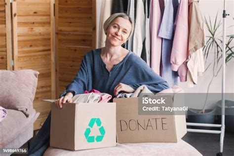옷으로 골판지 재활용 상자를 들고있는 행복한 중년 여성 기부함에 대한 스톡 사진 및 기타 이미지 기부함 의류 자선기부 Istock