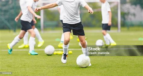 축구 훈련에 아이들 잔디밭에서 축구공을 차는 어린 소년들 학교 운동장에서 축구를 연습하는 익명의 어린이 그룹 Soccer Tournament에 대한 스톡 사진 및 기타