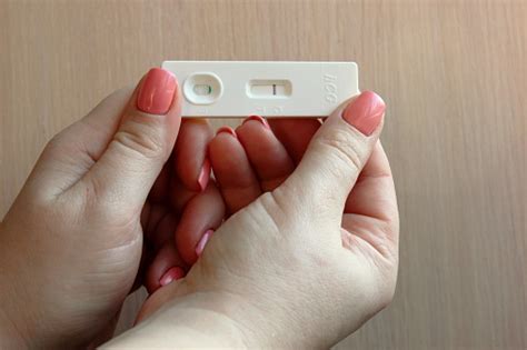 여자는 가벼운 배경에 부정적인 임신 테스트를 들고 분홍색 손톱과 손입니다 모성 임신 피임의 개념 건강 문제 및 임신 문제 복사 공간 가족에 대한 스톡 사진 및 기타 이미지