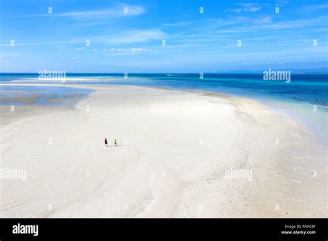 Aerial View Of Mother And Son On White Coral Sand Island And Clear