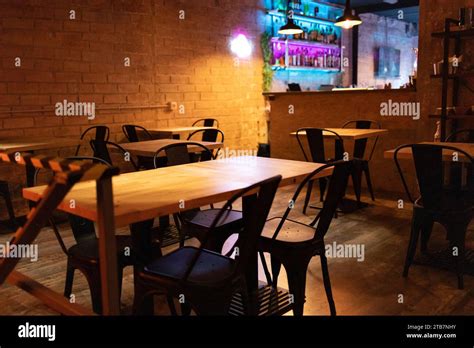 An Empty Cozy Bar Interior With Wooden Tables Metal Chairs And A Warm Dim Lighting Ambiance