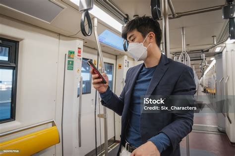 양복을 입은 아시아 사업가 여객 남성은 휴대 전화를 사용하여 보호 얼굴 마스크를 착용하고 Bts 스카이 트레인 또는 Mrt 지하철 철도 플랫폼에서 출근하는 동안 철도