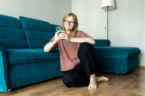 아파트 바닥에 소파 근처에 앉아서 웃고 핸드폰을 사용하는 아름다운 백인 기뻐하는 여성 전화 통신 및 편안함 개념 전신 30 39세에 대한 스톡 사진 및 기타 이미지 Istock