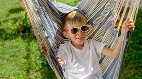 Un Jovencito Alegre Vestido Con Gafas De Sol Se Cala Y Se Reclina En