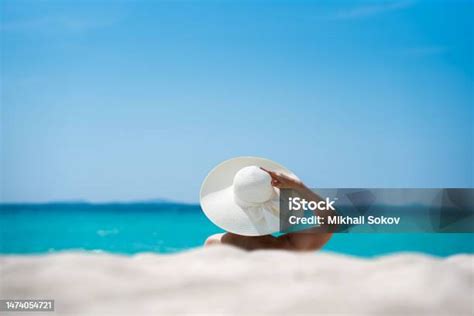 해변의 하얀 모래 위에 모자를 쓴 소녀 여름 방학의 개념은 바다와 태양을 즐기는 모자를 쓴 일광욕을하는 여성입니다 관광 리조트에 대한 스톡 사진 및 기타 이미지 Istock