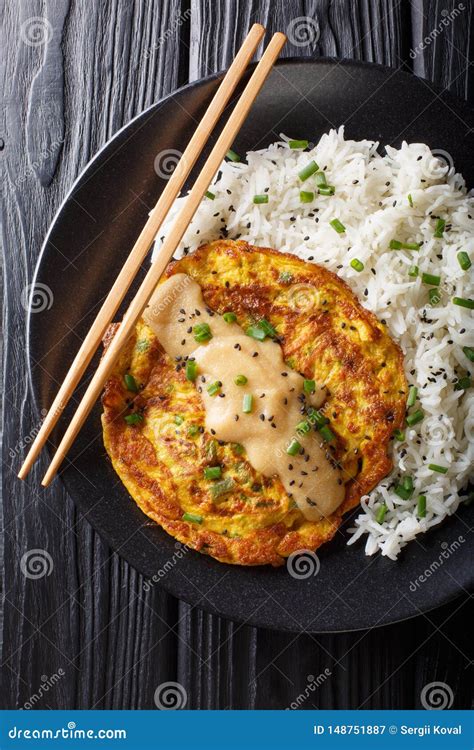 Egg Foo Yong Fried Egg Patty Containing Vegetables And Meat With Rice Garnish Close Up On A