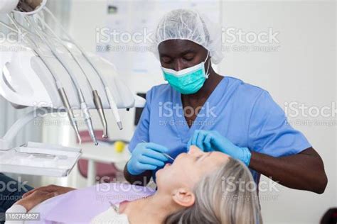 치과 의사는 진료소에서 치과의 자에 앉아있는 여성 환자를 치료 합니다 건강관리와 의술에 대한 스톡 사진 및 기타 이미지 건강관리와 의술 고객 남자 Istock