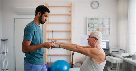 물리학실에서 노인 환자와 함께 운동하는 젊은 물리치료사 사진 Unsplash의 허리 통증 이미지