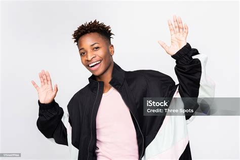 행복 한 아프리카 미국 남자 힙 스터 세련 된 유행 의상을 입고 흰색 배경 위에 스튜디오에서 춤을 추며 재미있게 시간을 보내며