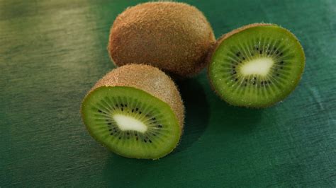 녹색 나무 판에 키 위 과일 전체 키위 과일과 얇게 썬 키위 과일 건강 식품 테마 건강한 라이프 스타일 테마 다이어트 테마 건강 과일 테마 건강한 생활방식에 대한 스톡 사진